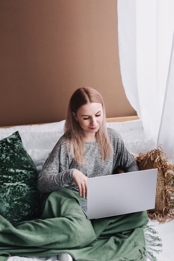 Young Woman Working on Computer in Bed. Relaxing at Home. Stock Photo ...