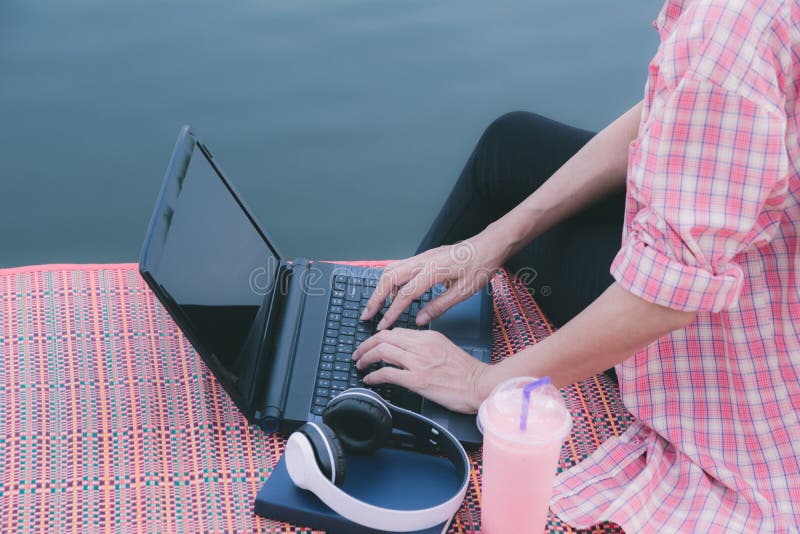 A Woman Using Laptop Computer while Sitting beside River Stock Image ...