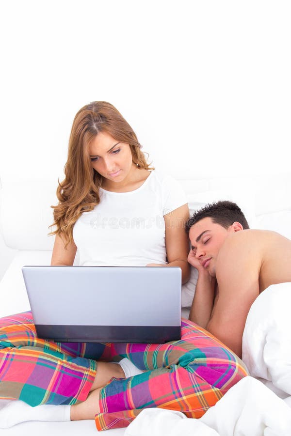 Woman Using Laptop and Partner Sleeping beside Her in Bed Stock Image ...