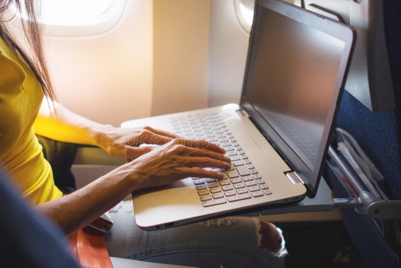Woman Using Laptop while is Sitting in Plane Near Window. Stock Photo ...