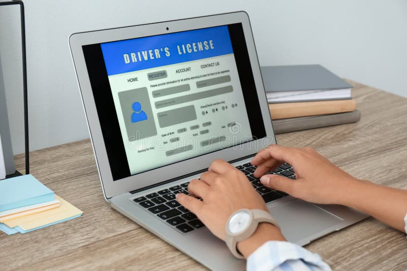Woman Using Laptop To Fill Driver`s License Application Form At Table ...