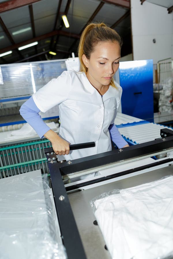 Woman Using Machine To Seal Linen in Plastic Stock Image - Image of ...