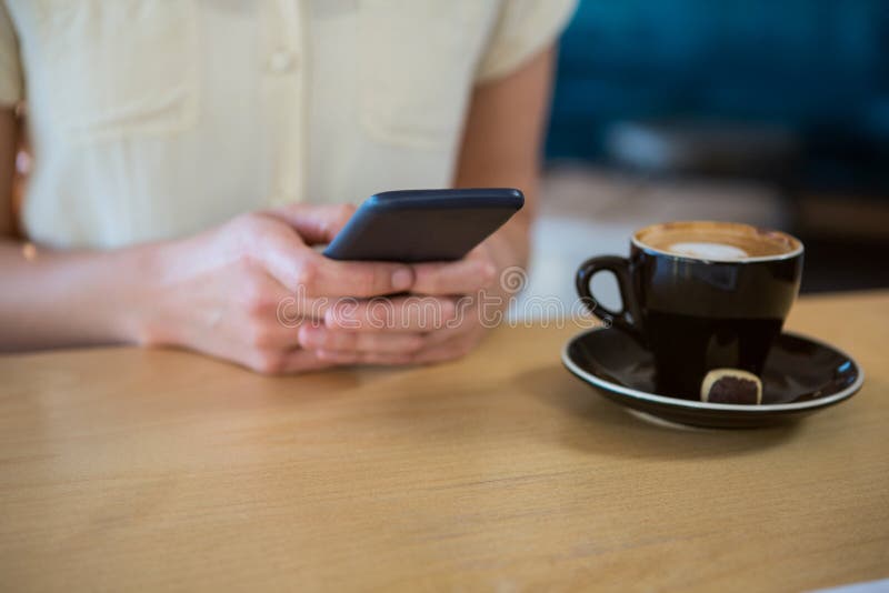 Woman Using Mobile Phone with Coffee Cup on Table Stock Image - Image ...