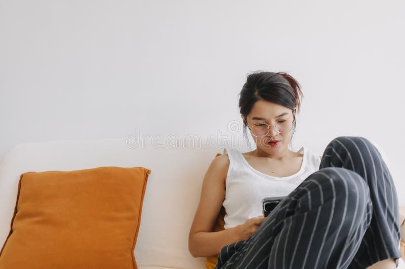 Woman Using Mobile Phone and Relax Sit and Lying on the Sofa. Stock ...