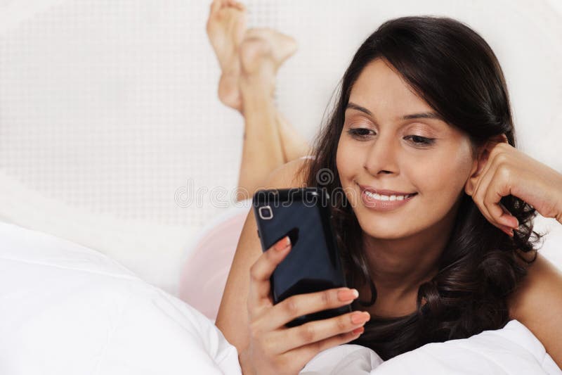 Woman using a mobile phone stock photo. Image of bedroom - 36255968