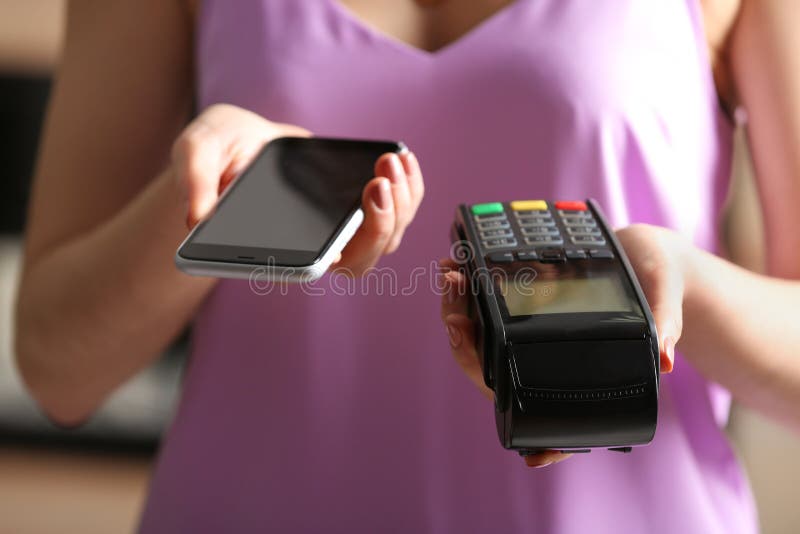 Woman Using Modern Payment Terminal with Mobile Phone Indoors Stock ...