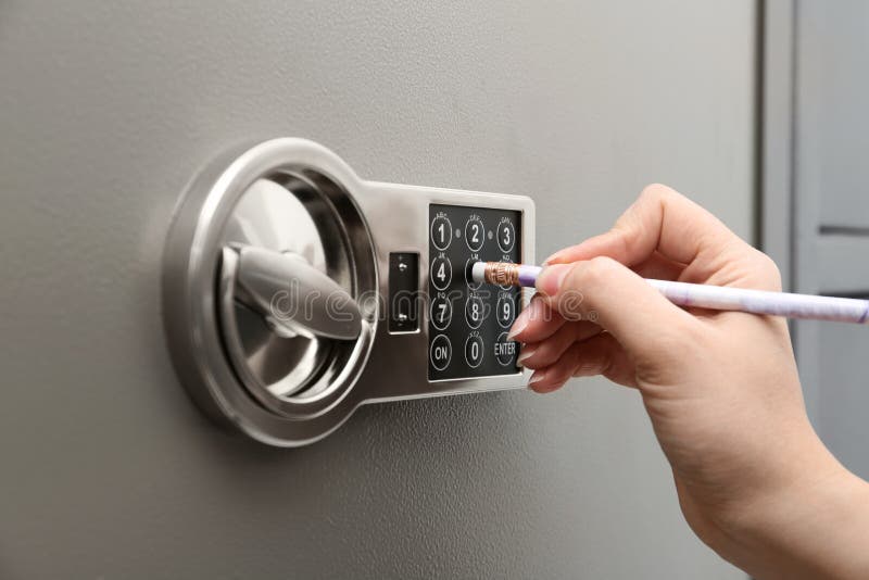Woman Using Pencil To Enter Code on Keypad of Safe, Closeup Stock Photo ...