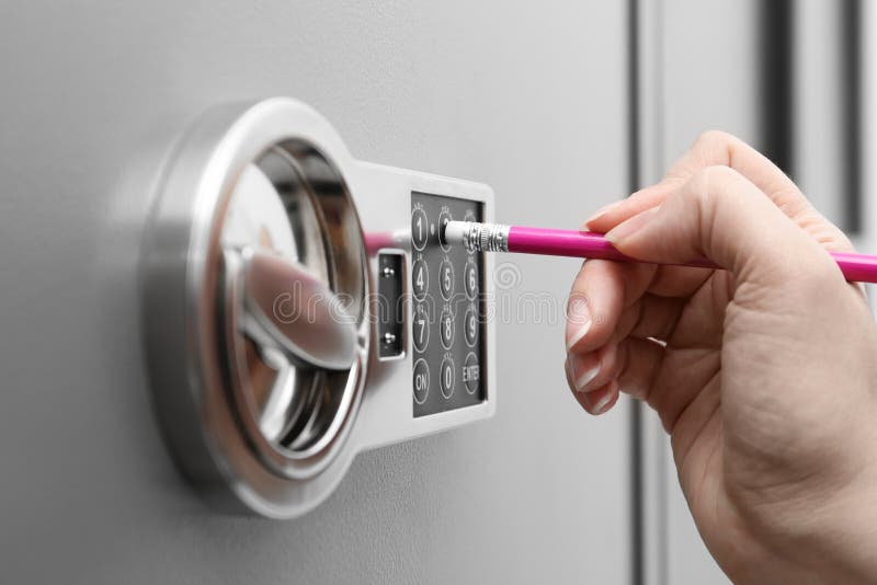 Woman Using Pencil To Enter Code on Keypad of Safe, Closeup Stock Photo ...