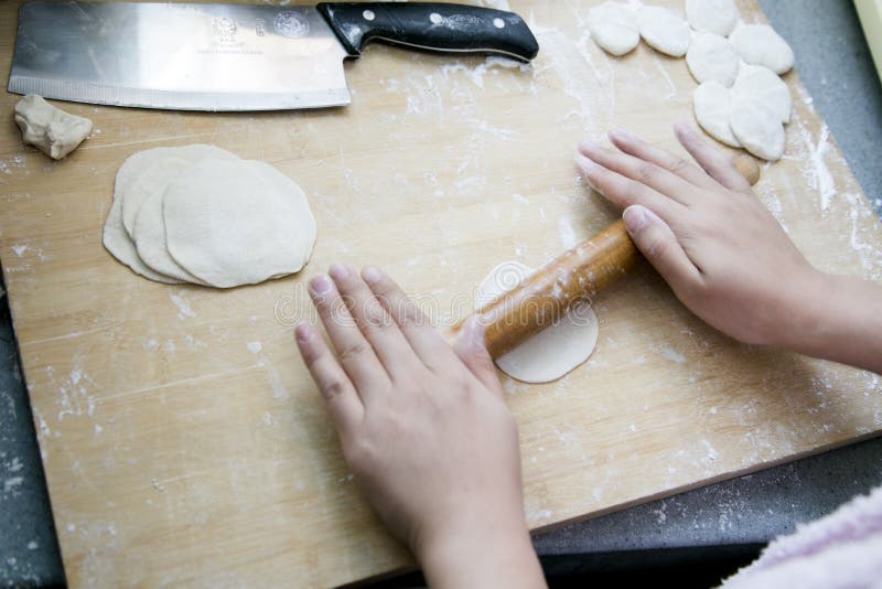 A Woman Using a Rolling Pin To Make Dumpling Skin Stock Image - Image ...