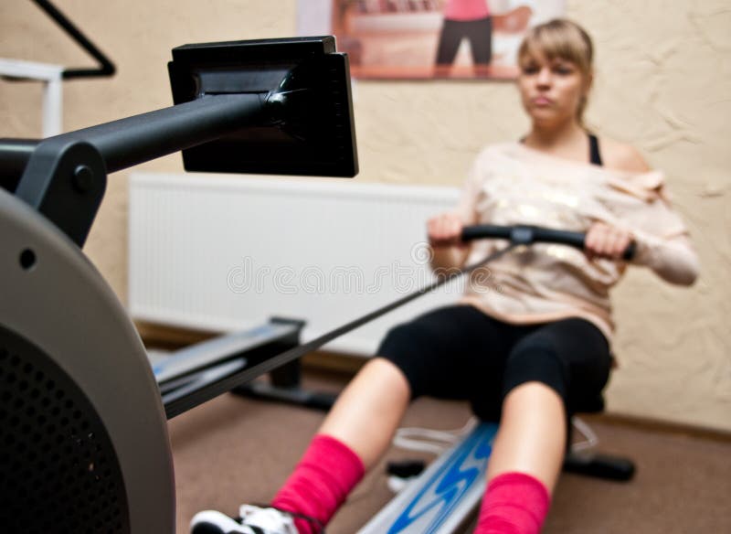 Woman using rowing machine stock photo. Image of machinery - 36018960