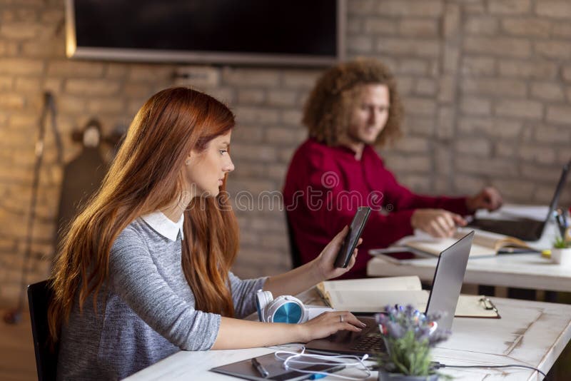 Woman Using a Smart Phone while Working at the Office Stock Photo ...