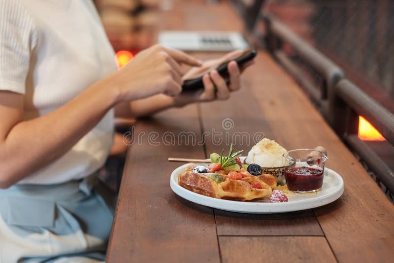 Woman Using Smartphone and Eating Dessert with Fresh Berries and Fruit ...