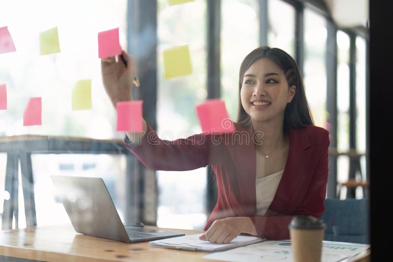 A Woman Using a Sticky Note and Analysis Data Report during Writing ...