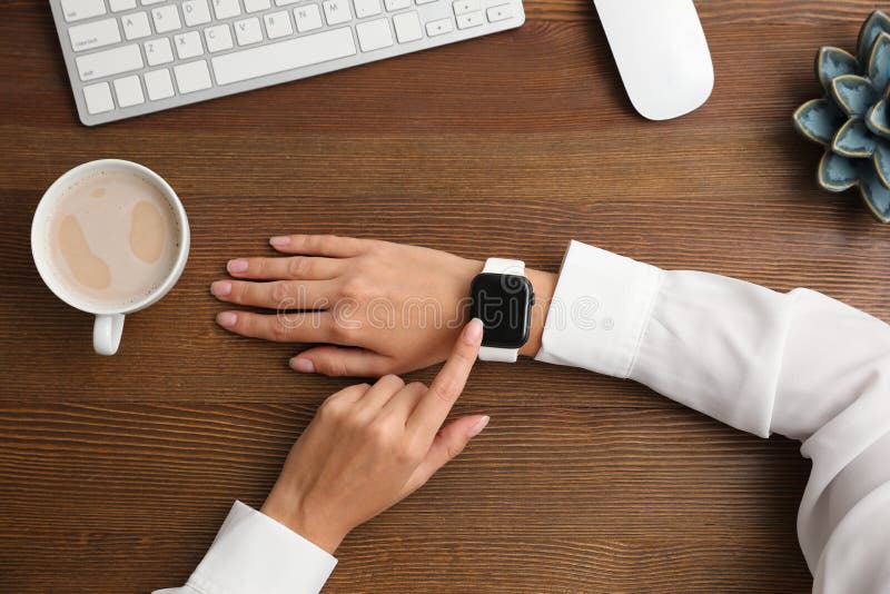 Woman Using Stylish Smart Watch at Wooden Table, Top View Stock Image ...