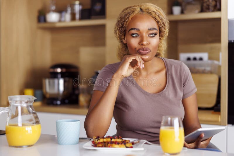 Woman Using Tablet Computer while Eating Breakfast at Home Stock Image ...