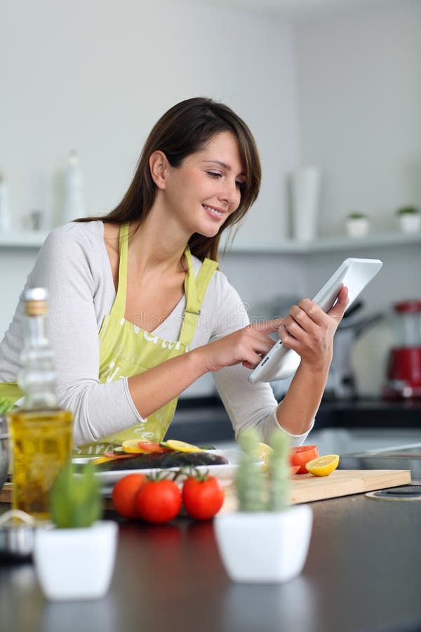Woman Using Tablet in Kitchen Stock Photo - Image of food, cooker: 27186098