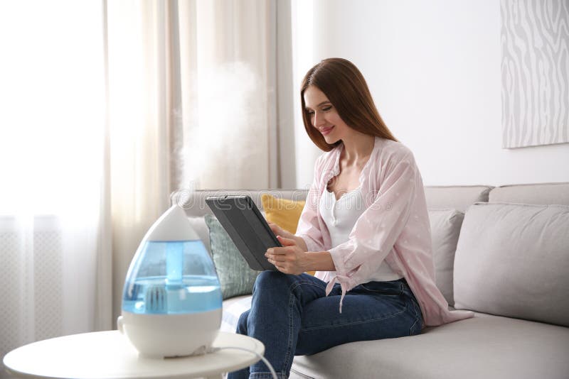 Woman Using Tablet in Room with Air Humidifier Stock Image - Image of ...