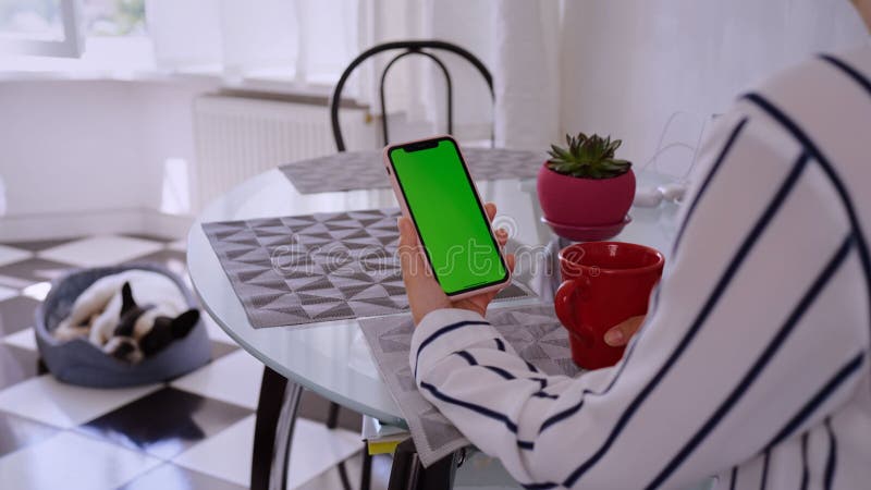 Woman Using Their Phone with a Green Screen Effect while Drinking Tea ...