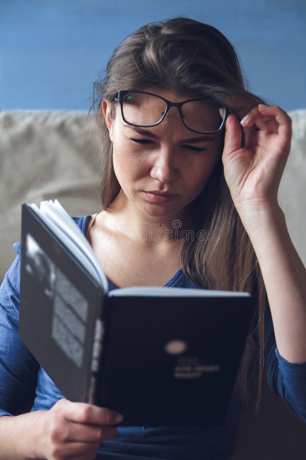 A Woman with Vision Problems is Reading a Book with Glasses Stock Image ...