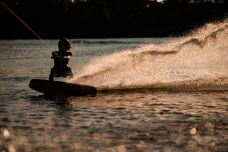 Woman Wakeboarder Holds Taut Cable and Standing on Wakeboard on the ...
