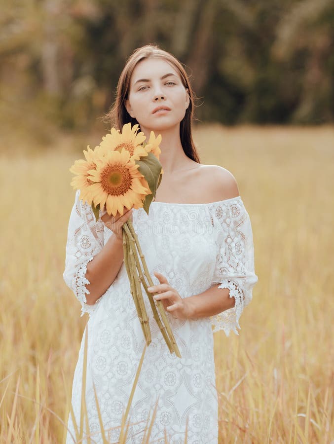 Woman Walking In A Field And Holding A Bouquet Of Sunflowers Portrait