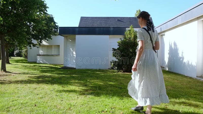 Woman Walking Gracefully Along Sunny Path by Modern White Building ...