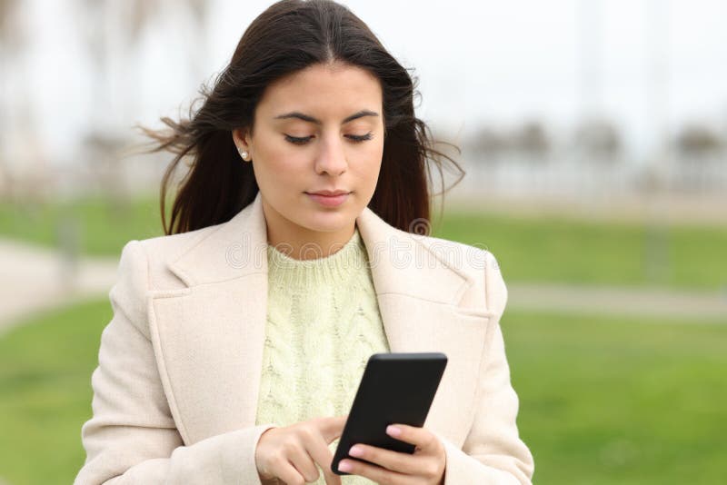 Woman Walking Using Smart Phone in a Park Stock Photo - Image of ...