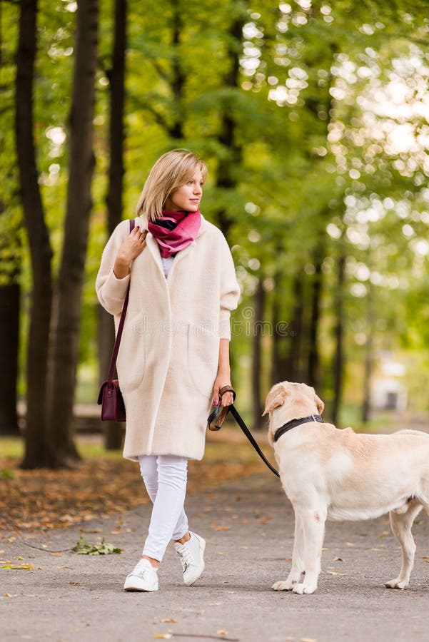 A Woman Walks with Her Labrador in the Fall. Stock Image - Image of ...