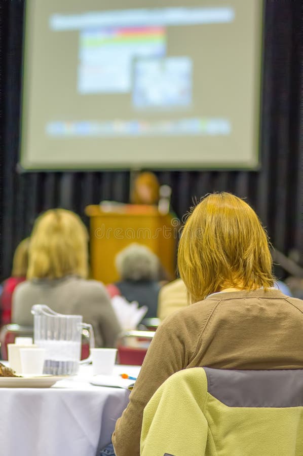 Woman Watching Keynote Speaker at a Conference with a Slide Deck ...