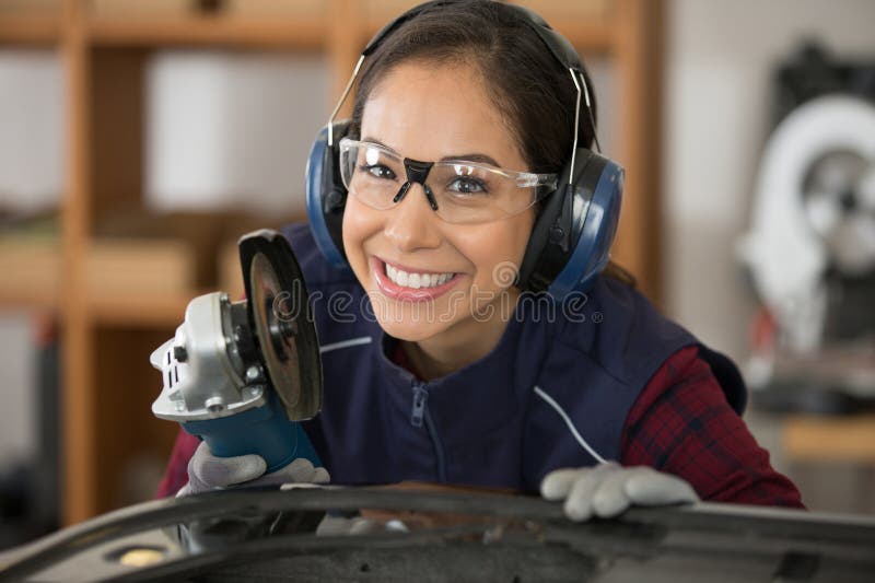 Woman Wearing Ear Protection and Glasses Using Electric Grinder Stock ...