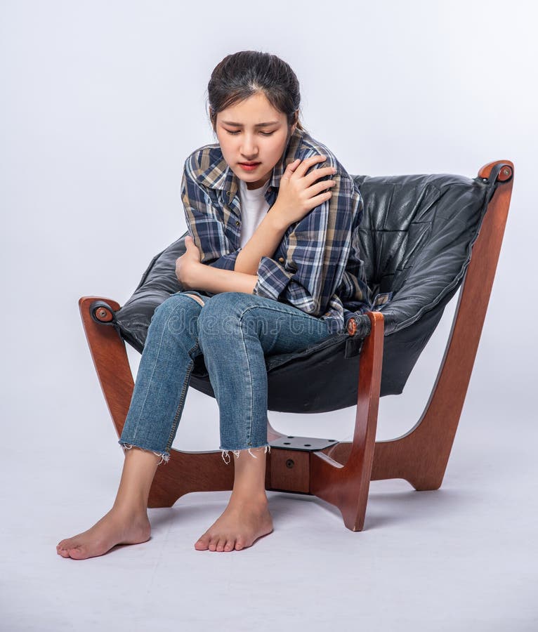 A Woman Who is Uncomfortable and Sits on a Chair Stock Image - Image of ...