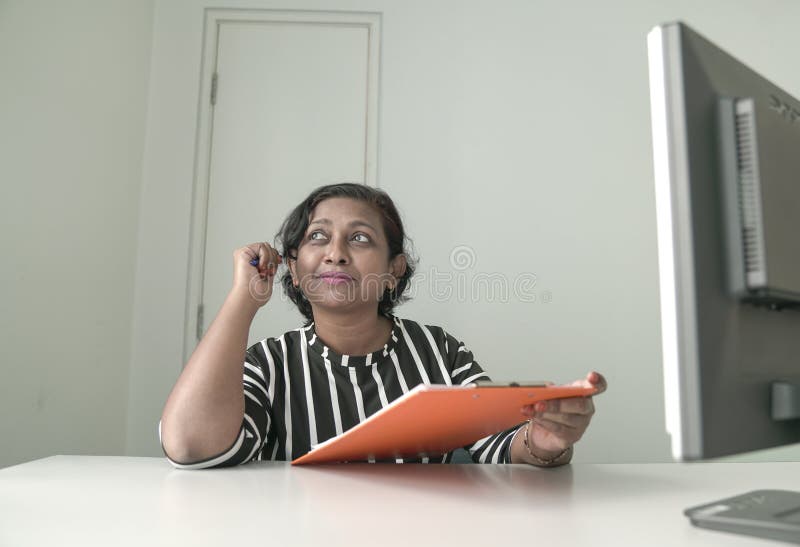 Woman at Work, Holding a File, with a Thinking Expression Stock Photo ...