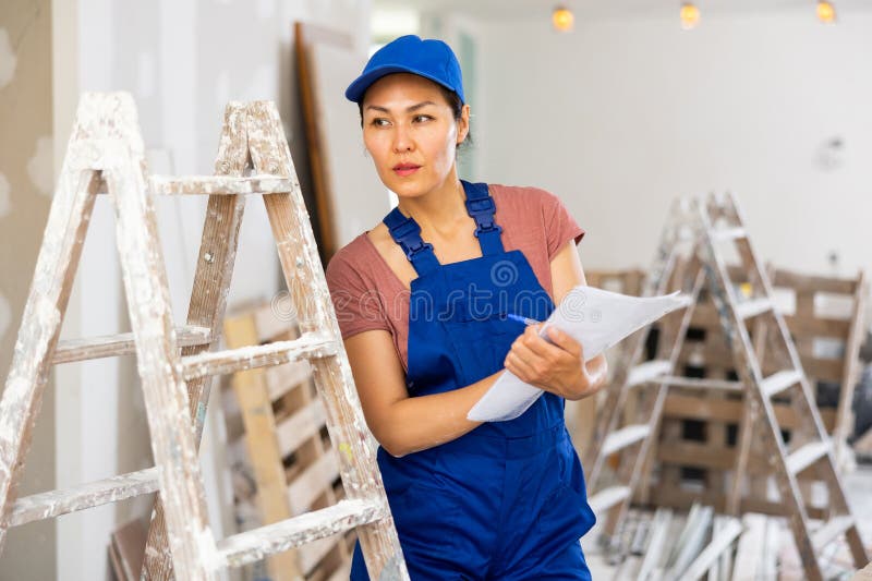 Woman Worker Checking Documents during Repair Works Stock Image - Image ...