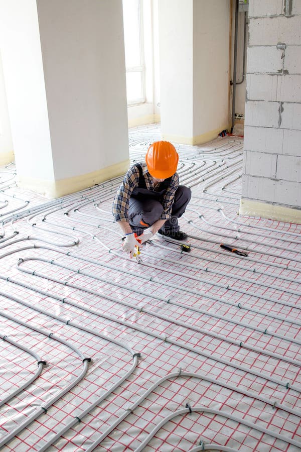 Woman Worker is Installing Underfloor Heating System. Warm Floor ...