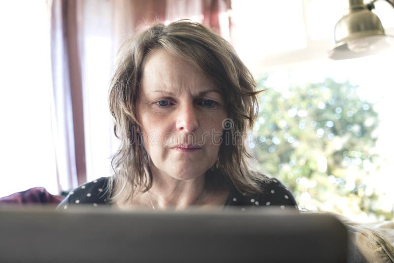 Woman Working on Computer at Home with Window Behind Her Stock Image ...