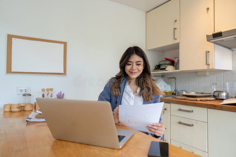 Woman Working from Home in Dining Room with Laptop and Documents ...