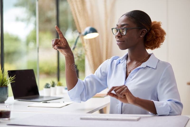 Woman Working from Home Office Sitting at Desk Interacting with AR or ...