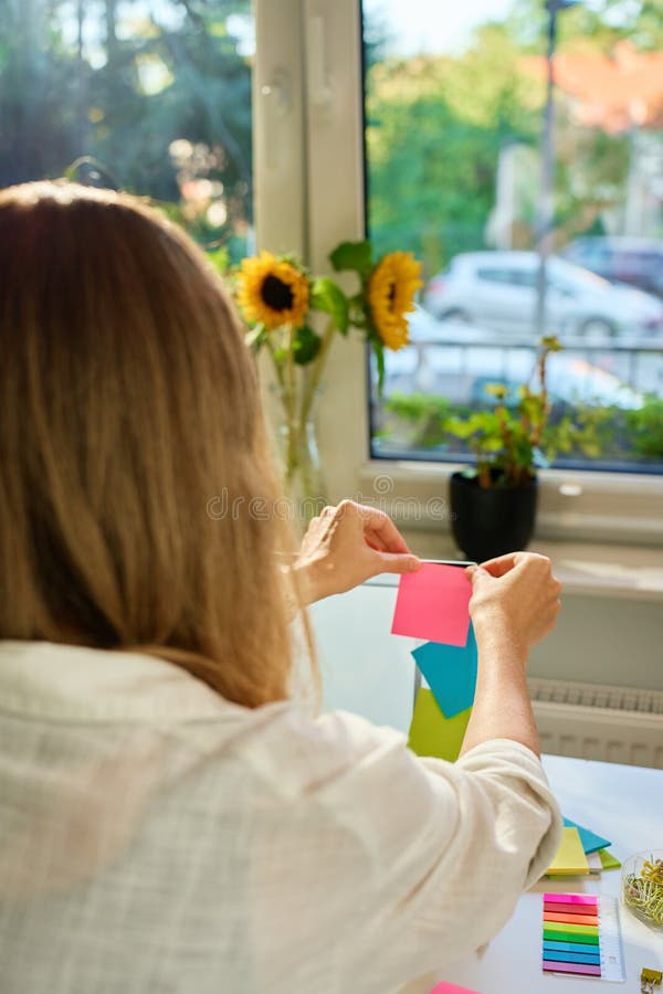 Woman Working from Home Using Sticky Notes To Organize Her Work on Her ...