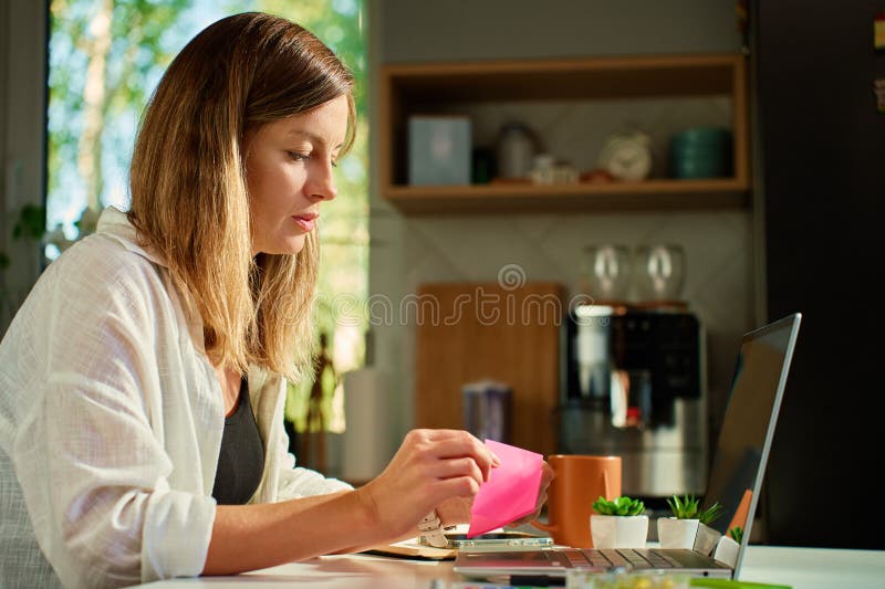 Woman Working from Home Using Sticky Notes To Organize Her Work on Her ...