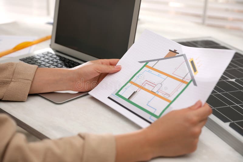 Woman Working on House Project with Solar Panels at Table in Office ...