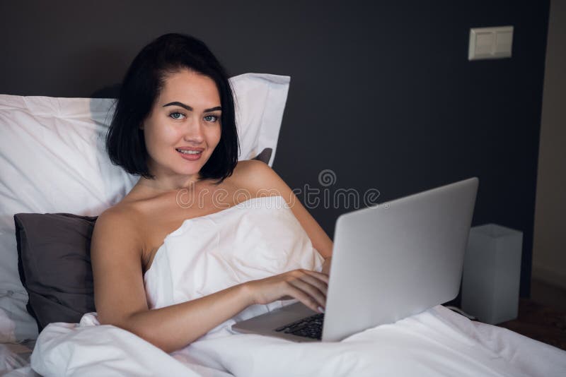 Woman Working on Laptop Computer while Lying on a Bed at Home. Stock ...