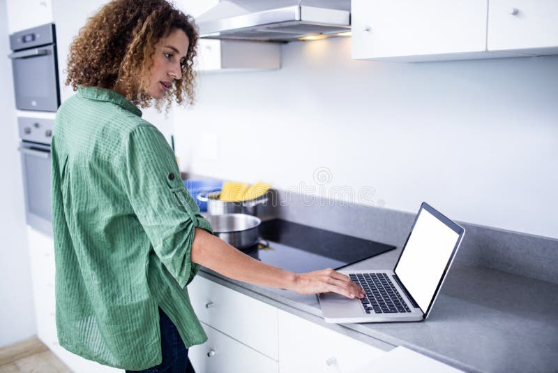 Woman Working on Laptop while Cooking Stock Image - Image of making ...