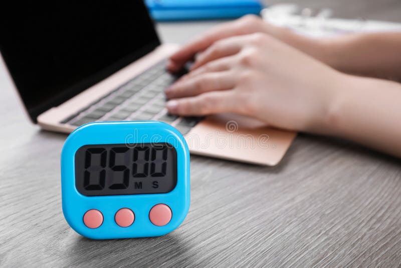 Woman Working on Laptop at Wooden Table, Focus on Kitchen Timer. Space ...