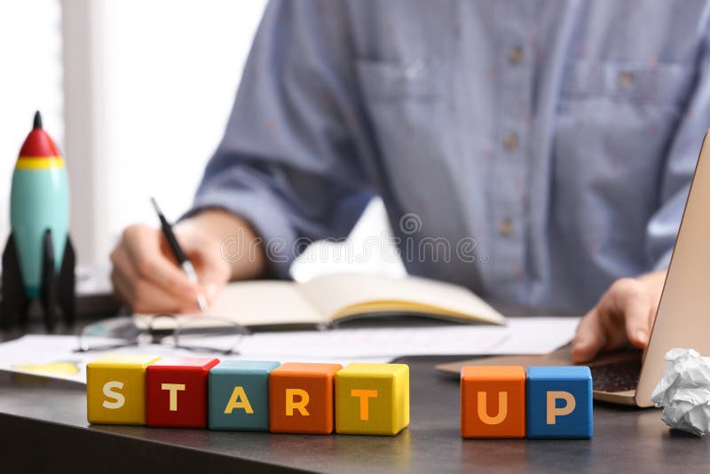 Woman Working at Messy Table, Focus on Colorful Cubes with Words Start ...