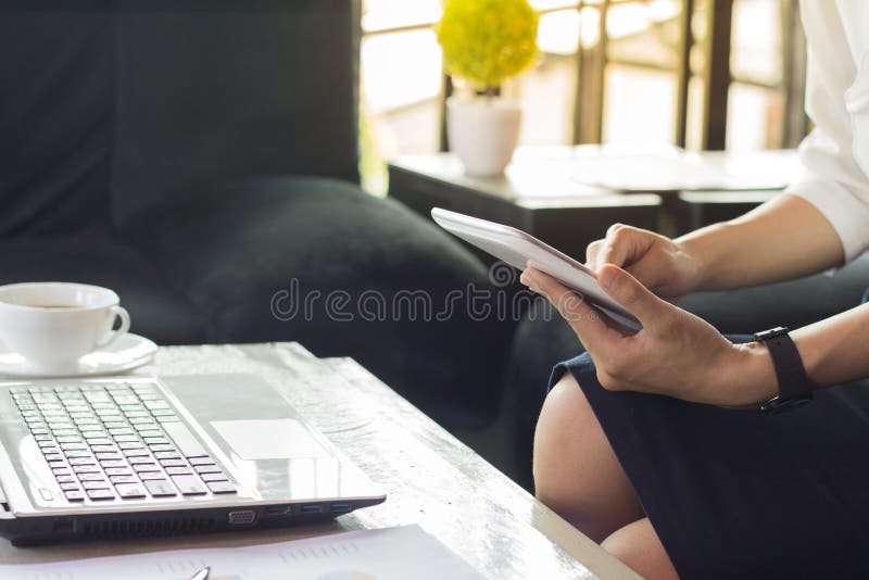 A Woman Working in an Office with a Cell Phone and a Computer Stock ...