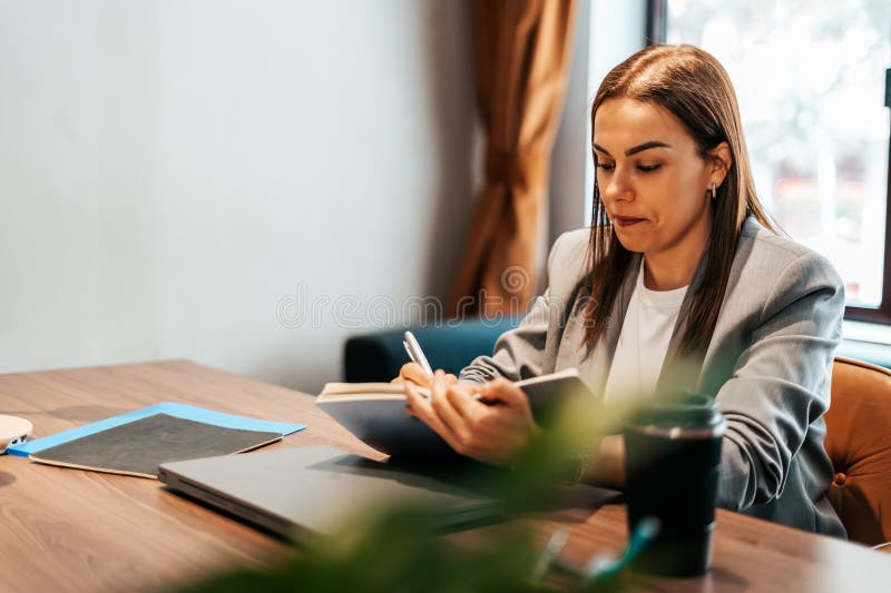 Woman Working in an Office Writing in Her Diary Stock Photo - Image of ...