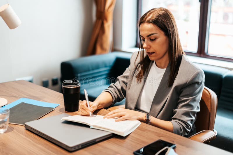 Woman Working in an Office Writing in Her Diary Stock Image - Image of ...