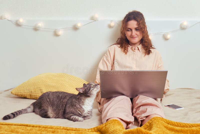 Woman Working Online on the Computer and Cat on the Bed Stock Photo ...