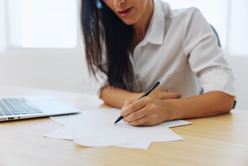 A Woman Works and Learns by Writing Down Text on Paper with a Pen and ...