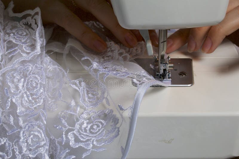 A Woman Works on a Sewing Machine. Sewing of Lace Fabric. Stock Photo ...
